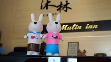 Duas figuras em uma estante, com uma placa indicando "Mulin inn" ao fundo.