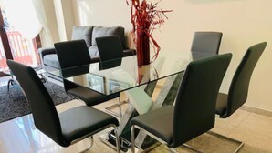 Uma sala de reuniões moderna com uma mesa de vidro e cadeiras pretas.
