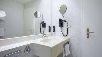 Uma casa de banho moderna com duas lavatórios, um espelho, um porta-toalhas e um secador de cabelo.