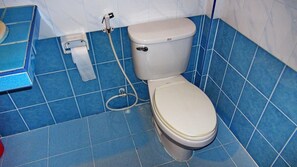 Casa de banho com sanita, azulejos azuis e lavatório branco.