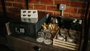 Uma área de cozinha com máquina de café, potes e utensílios sobre uma bancada de madeira.