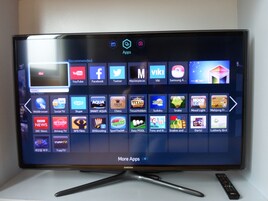Televisão de tela plana com um painel de ícones de aplicativos, incluindo YouTube, Facebook e Twitter.