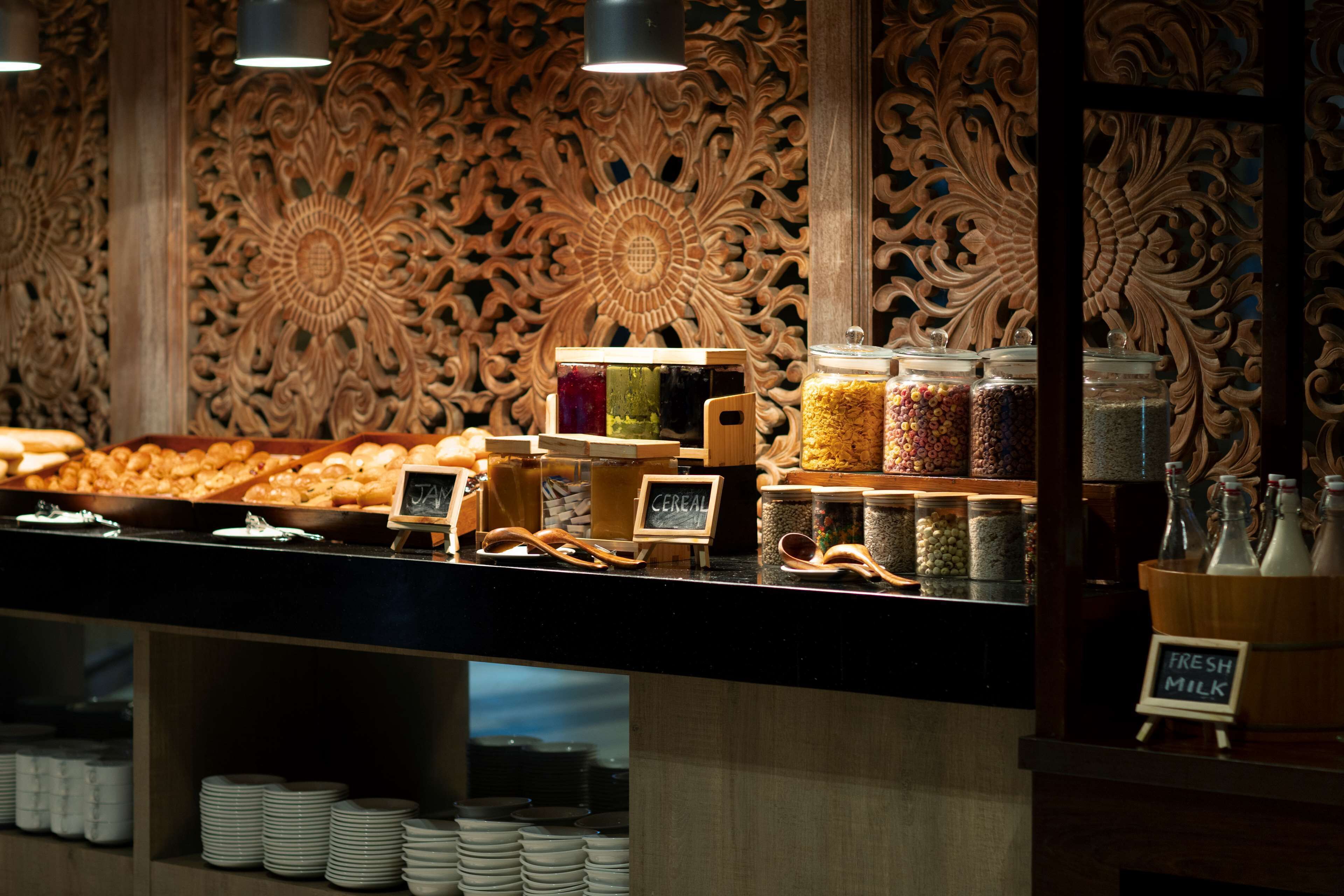 Buffet de café da manhã com diversos alimentos e um aviso indicando leite fresco.