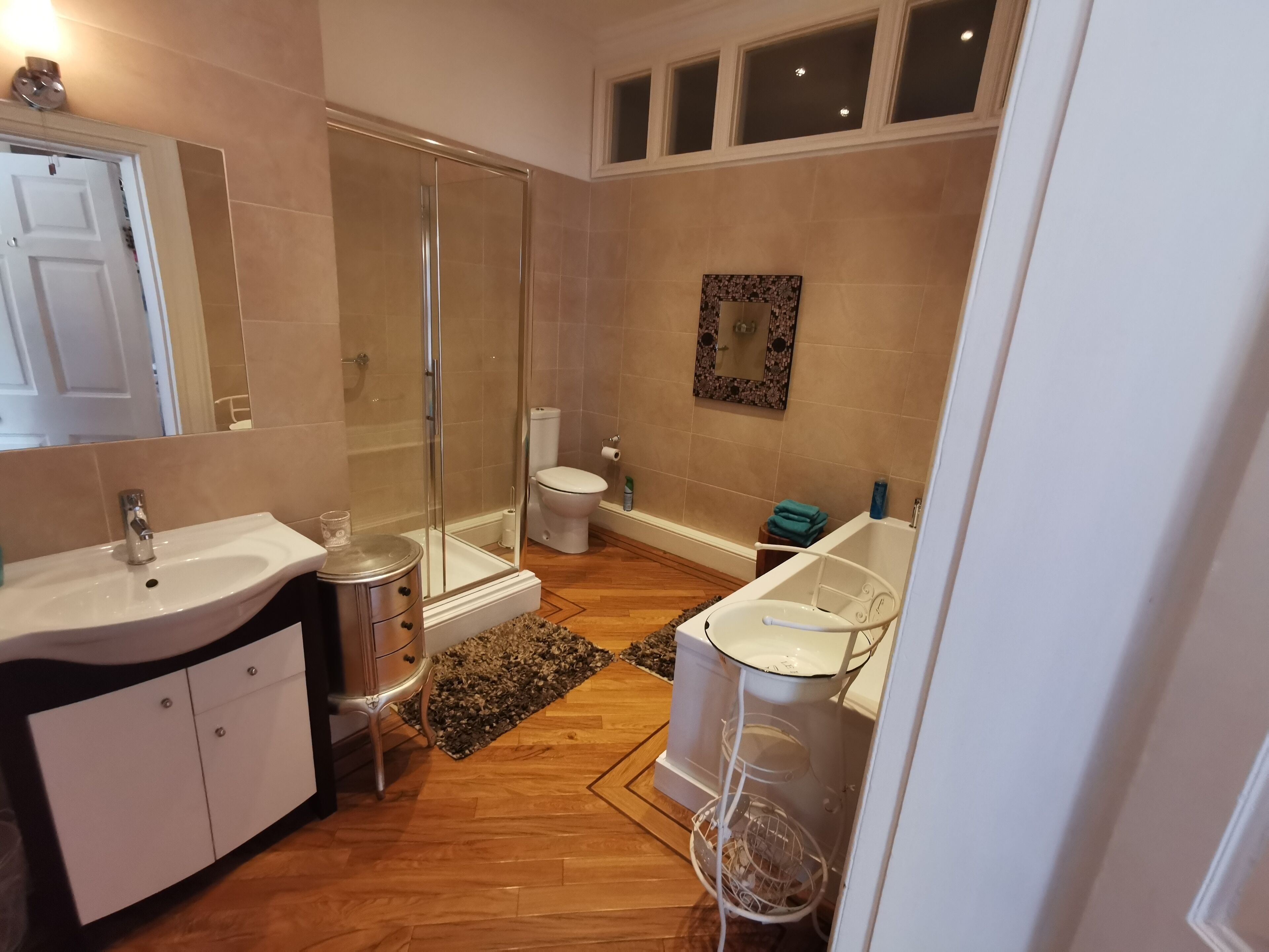 Casa de banho com chuveiro, sanita, lavatório e banheira.
