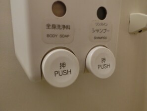 Painel de controle com dois botões rotulados 'PUSH' para sabonete líquido e shampoo.