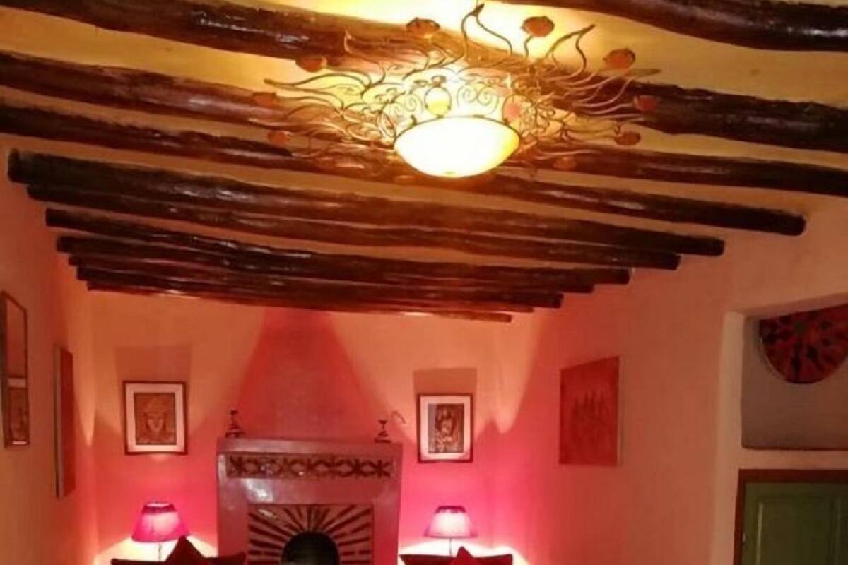 Um quarto aconchegante com duas camas, uma lareira e uma porta verde.