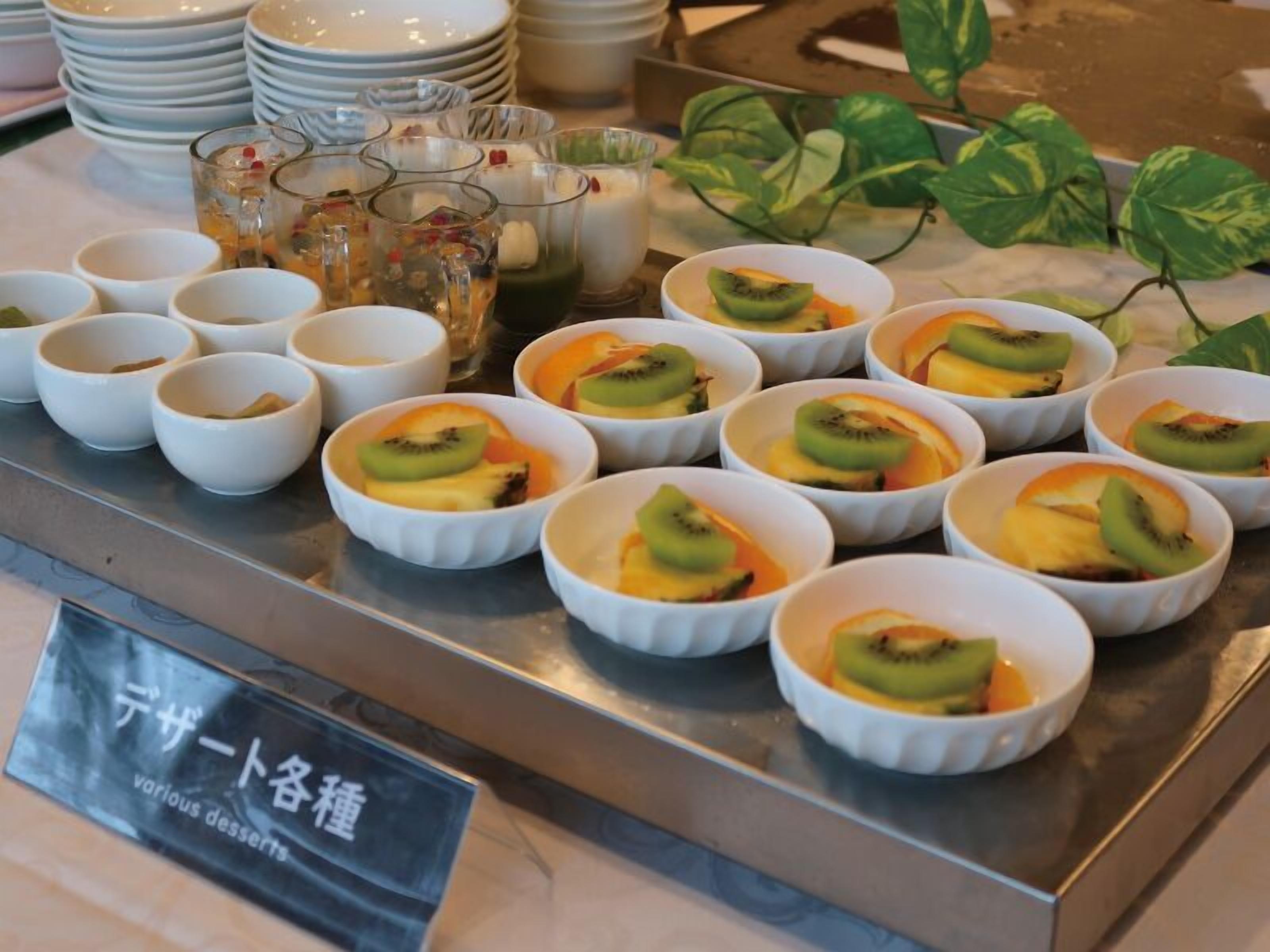 Exposição de sobremesas com diversos potinhos contendo doces com frutas, acompanhados por pequenos copos e um letreiro indicando 'várias sobremesas'.