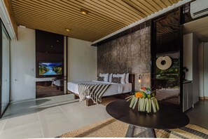 Quarto moderno com cama, TV, mesa de jantar com flores e uma janela grande.