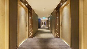 Corredor de hotel com portas de madeira numeradas de 4 a 6, dando acesso aos quartos.
