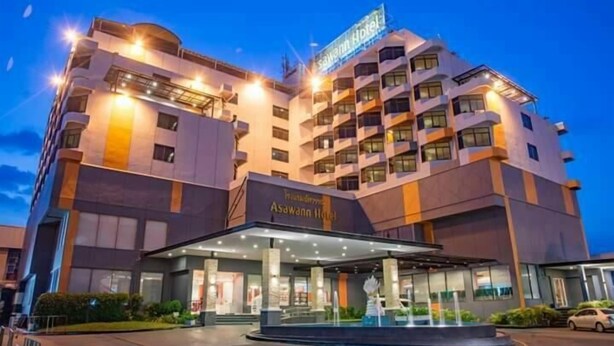 Um hotel de vários andares com uma entrada notável e uma placa indicando 