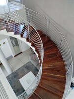 Uma escada em espiral com degraus de madeira e grades de metal.