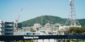 Um canteiro de obras com guindastes e uma grande torre de comunicação.