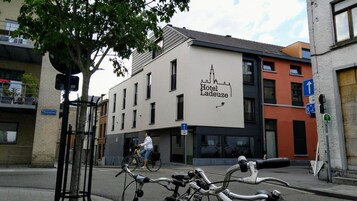 Um edifício com uma placa indicando Hotel Lageuze, apresentando um estilo arquitetônico moderno, com telhado plano e janelas amplas.