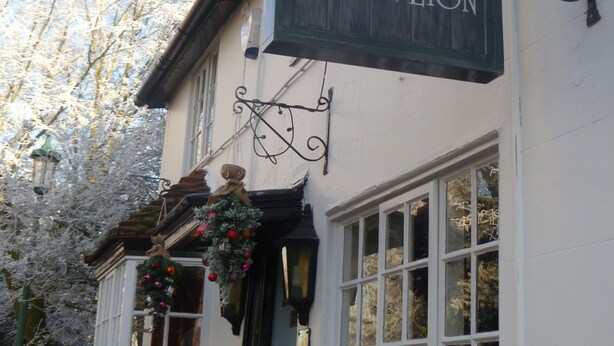 Um pub chamado "White Lion" com uma placa tradicional pendurada na parte externa.