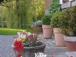 Um jardim com vasos de plantas e uma cesta de vime cheia de flores.