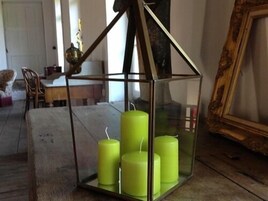 Um candelabro de vidro com velas sobre uma mesa de madeira.