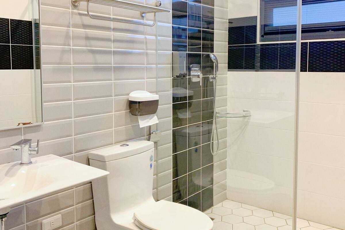 Uma casa de banho moderna com sanita, lavatório e cabine de duche em vidro.