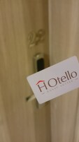 Porta de um quarto de hotel com uma placa que diz 'Hotello Guest Suites'.