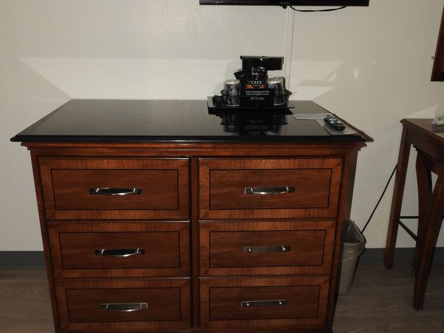 Uma mesa de madeira com gavetas e uma máquina de café.