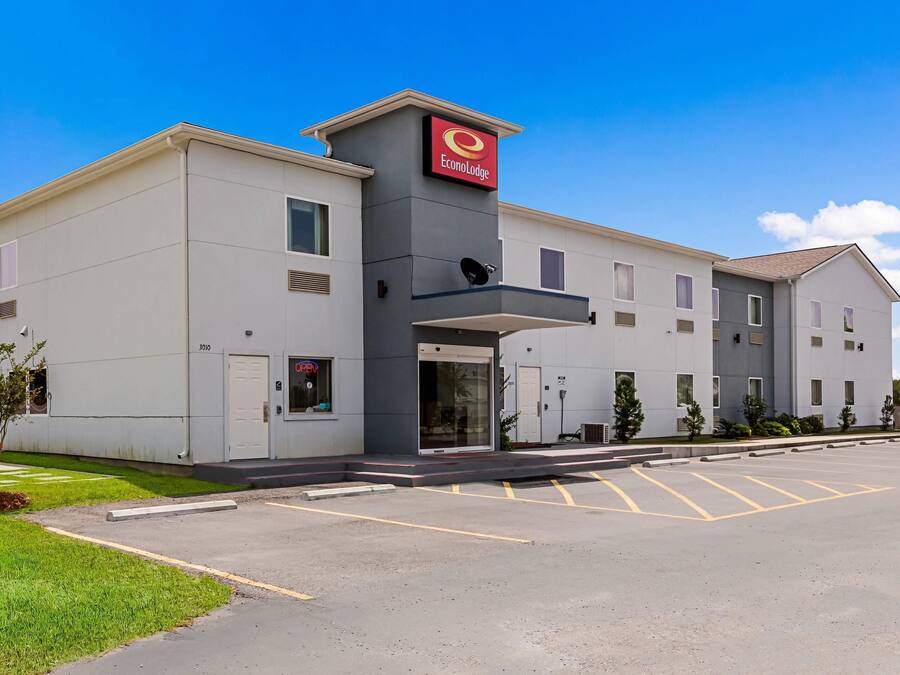 Um edifício moderno do EconoLodge com entrada destacada, estacionamento e gramado bem cuidado.