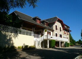 Um edifício de dois andares com varanda e uma placa que diz 'Hotel'.