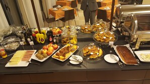 Buffet com diversas opções de comida e acompanhamentos.