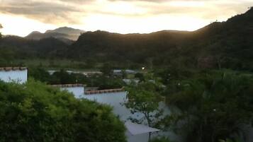 Vista de uma paisagem com um corpo d'água, rodeada por colinas e vegetação.