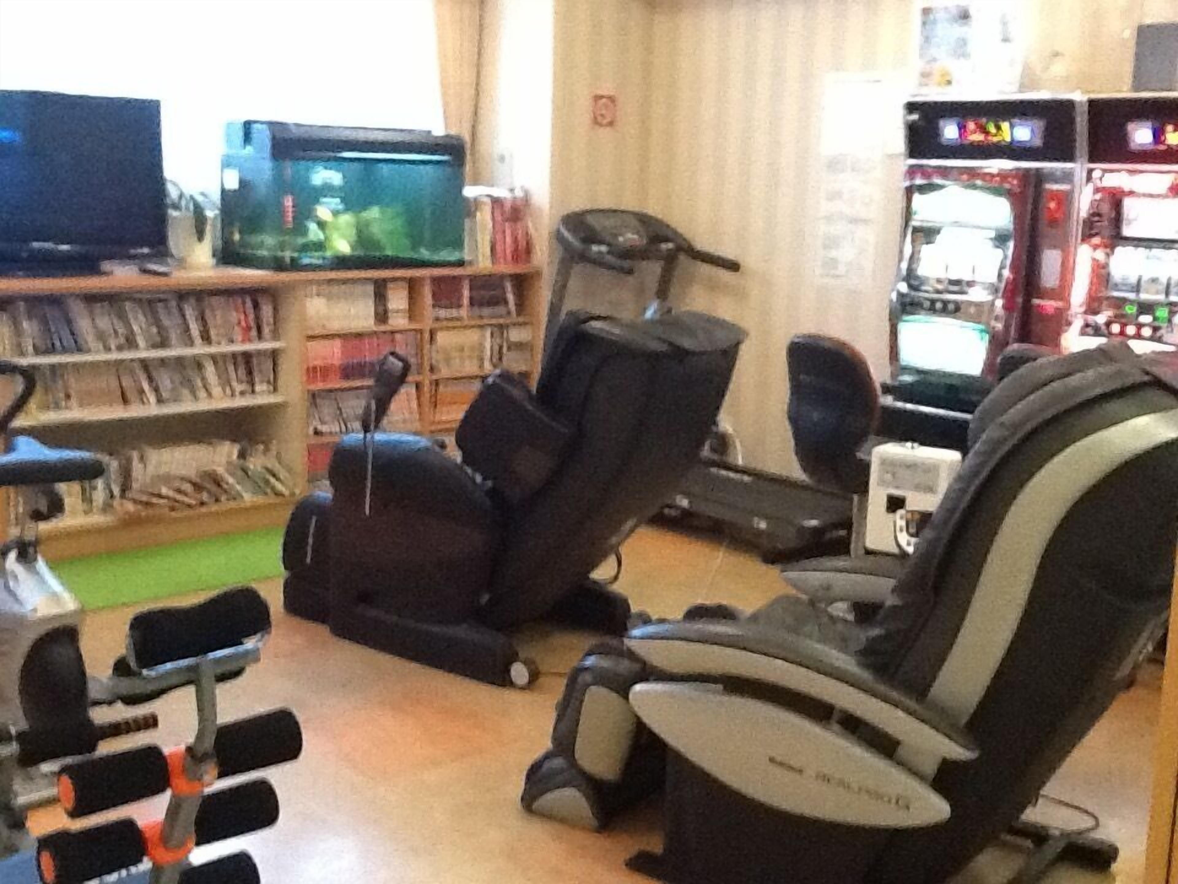 Uma academia em casa com equipamentos de ginástica, uma televisão e uma estante de livros.
