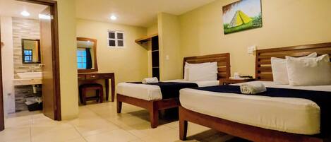 Quarto de hotel com duas camas, uma escrivaninha, uma cadeira, um espelho e um quadro na parede.