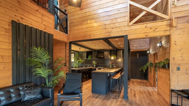 Um interior moderno com teto de madeira, área de bar e assentos.