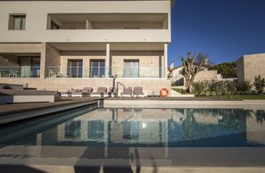 Um hotel moderno com piscina, área de estar ao ar livre e um flutuador.