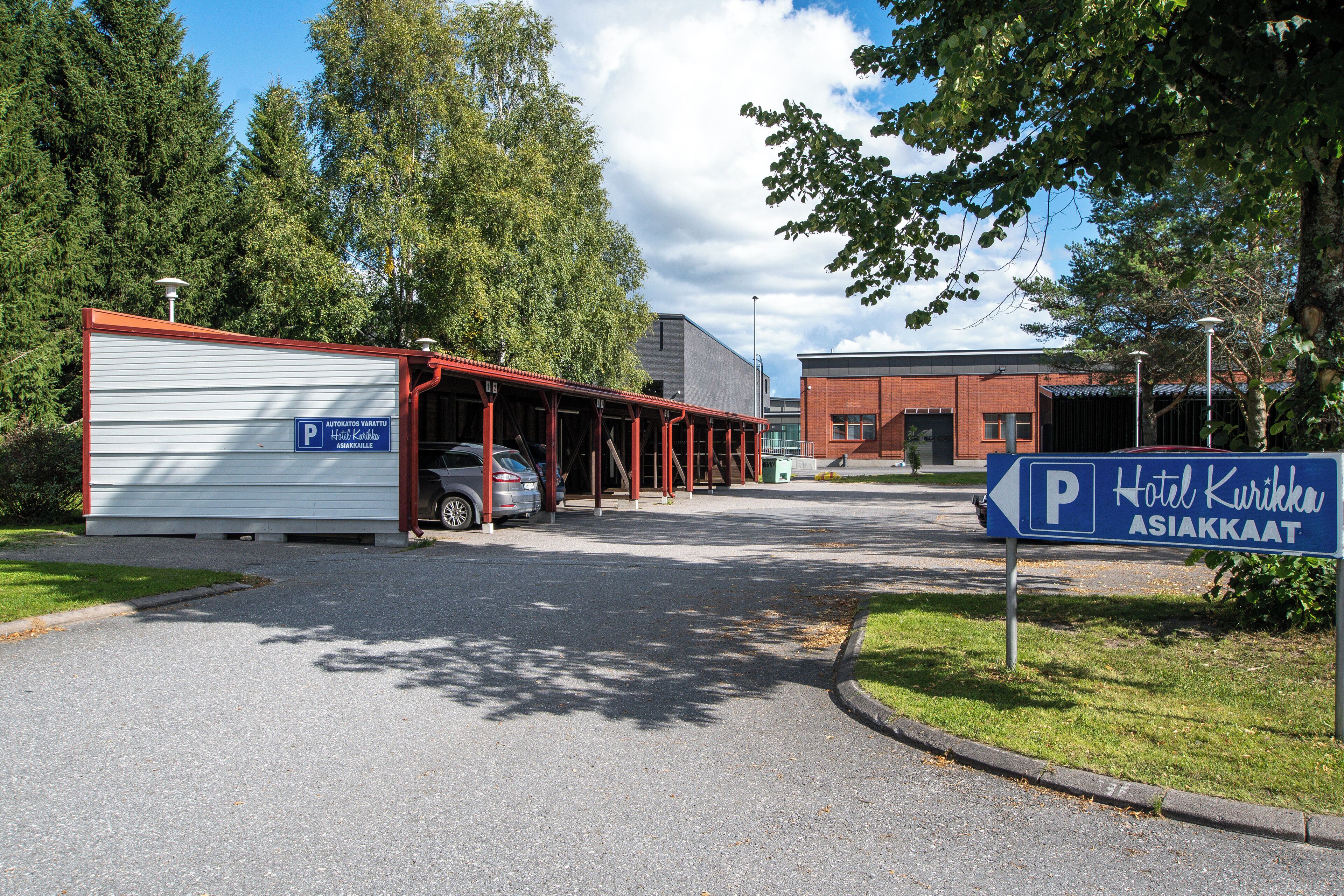 Uma área de estacionamento com uma placa para Hotel Kurikka Asiakkaat.