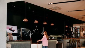 Uma área de recepção de hotel com design moderno, um balcão de recepção, espaço para sentar e um bar.