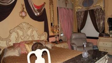 Quarto com uma cama grande, uma mesa de mármore e um candelabro.