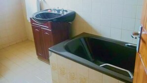 Uma cozinha pequena com pia, armário e paredes revestidas de azulejos.