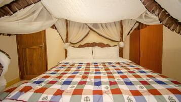 Uma cama com colcha xadrez, cabeceira de madeira e dossel com cortinas leves.