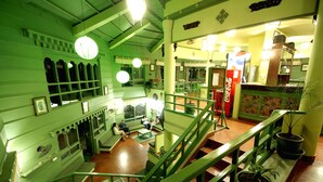 Um interior com vários níveis, paredes verdes, escada e áreas de estar.