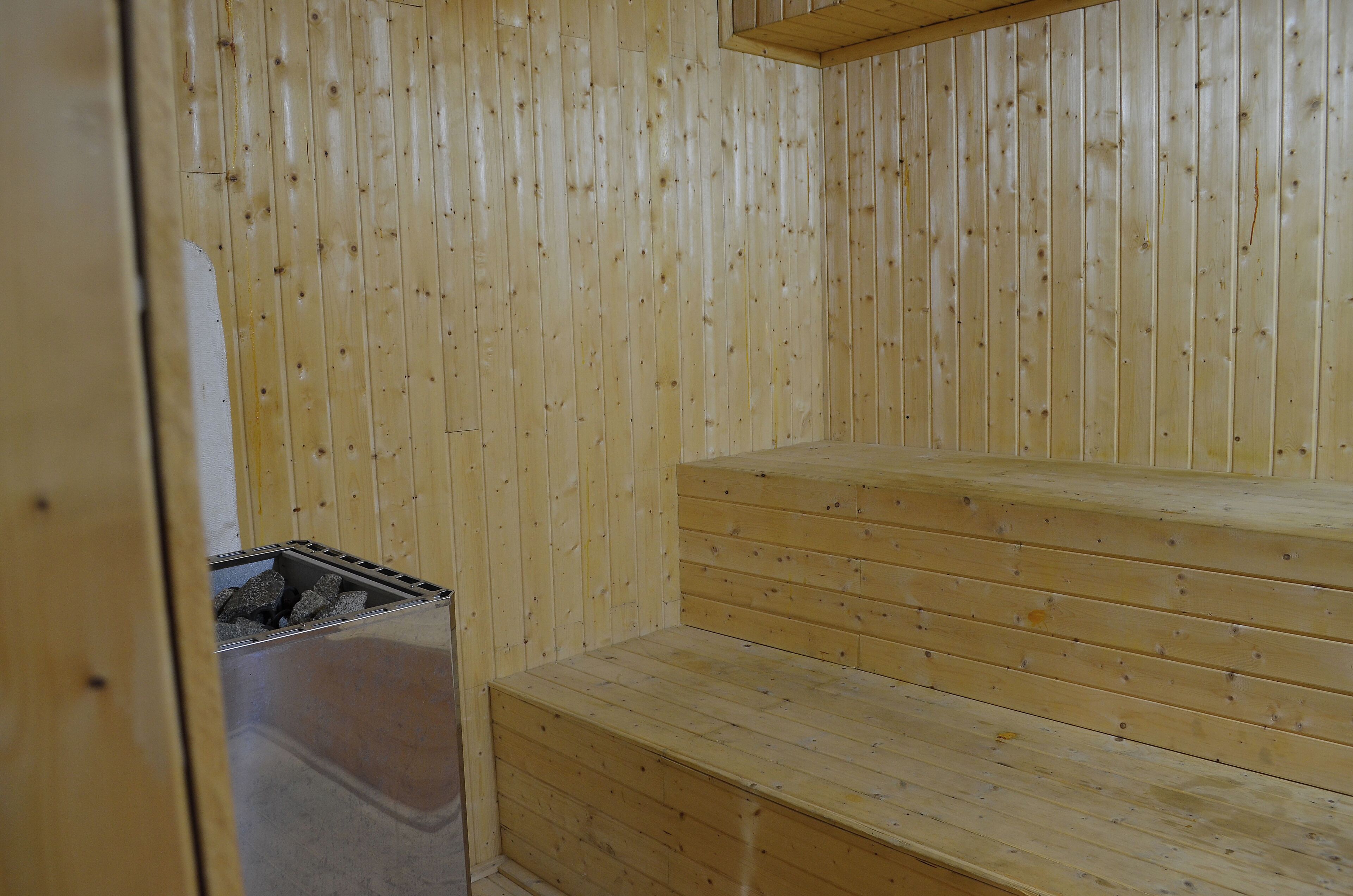 Uma sauna com paredes e bancos de madeira.