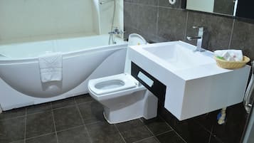 Um banheiro moderno com banheira, vaso sanitário e pia.