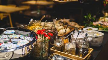 Uma mesa de buffet com diversos alimentos e utensílios.