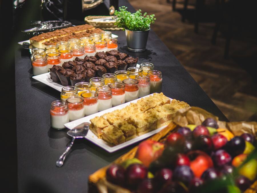 Uma mesa de buffet com diversos alimentos e um espaço para café.