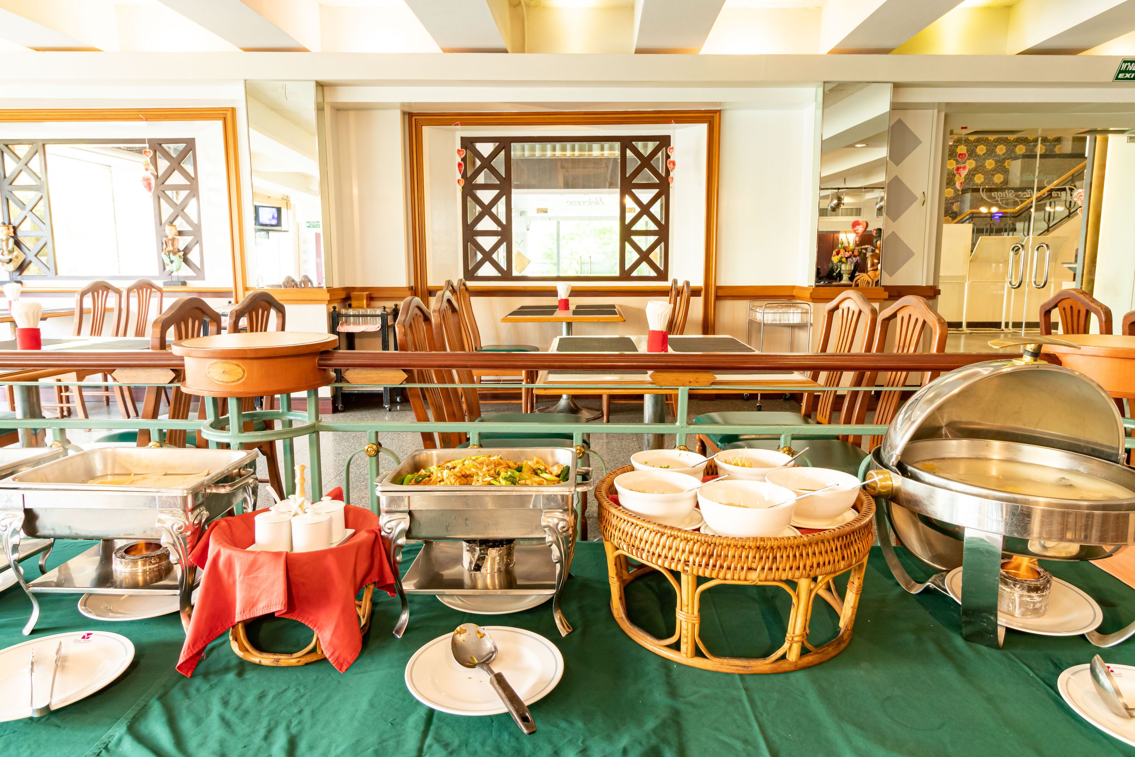 Disposição de buffet com várias estações de serviço, incluindo uma panela grande e diversos recipientes e pratos.
