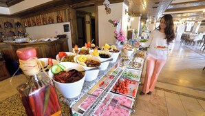 Buffet com diversos alimentos e uma garrafa de legumes em conserva.