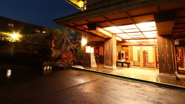 Um edifício japonês tradicional com entrada coberta e um candeeiro de pedra.
