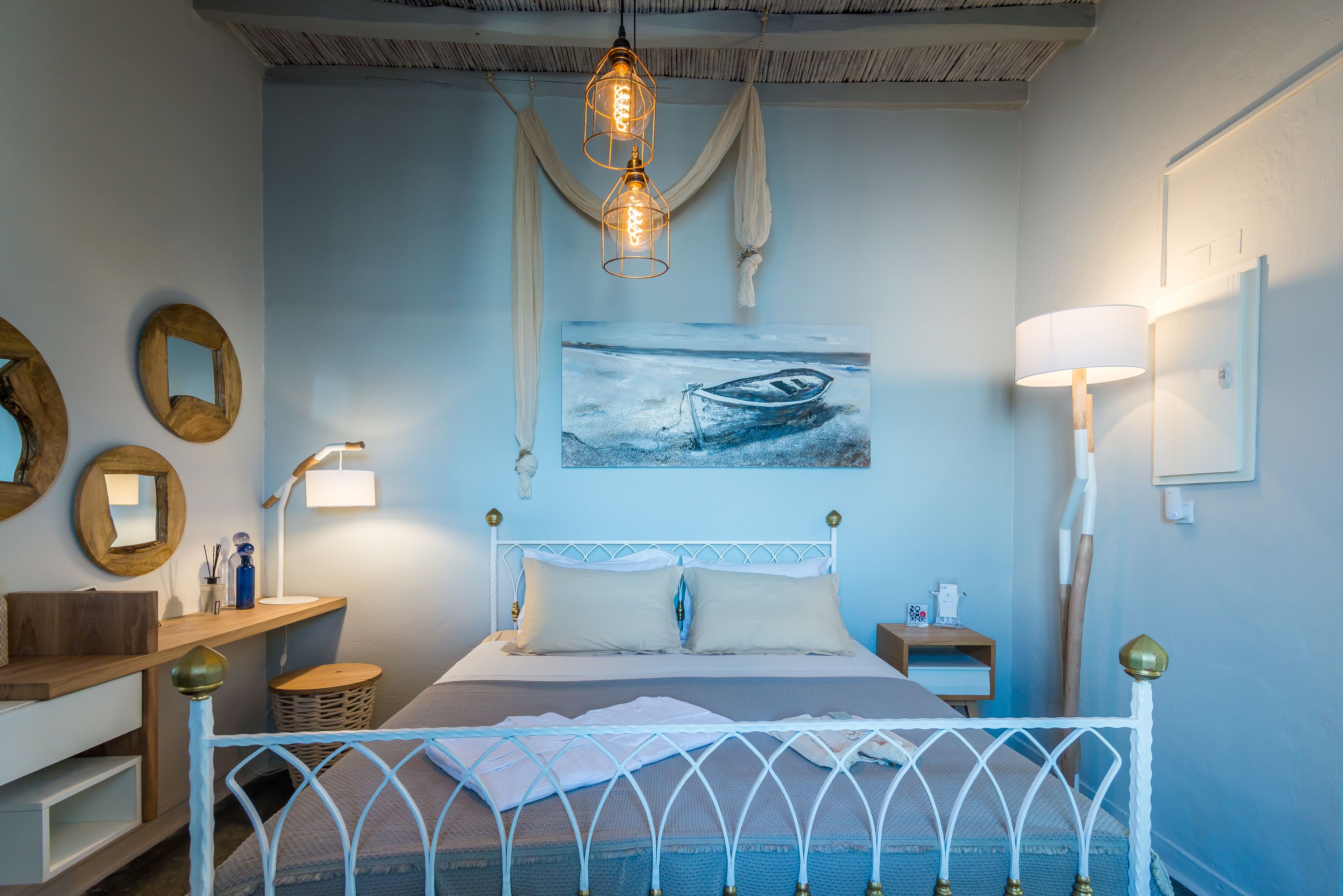 Quarto com cama, mesa de cabeceira, luminária e obra de arte na parede.