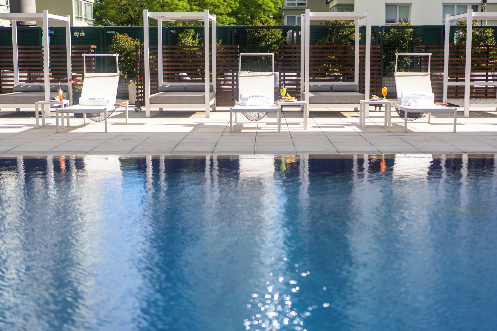 Uma piscina com espreguiçadeiras e espreguiçados.