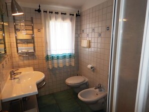 Apartamento, 2 quartos | Casa de banho | Um polibã, toalhas fornecidas 