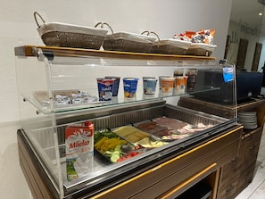Buffet com diversos alimentos e produtos lácteos.