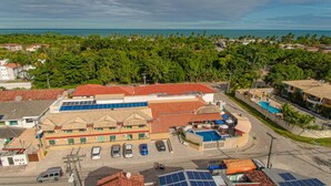 Um edifício grande com vários andares, estacionamento e piscina.