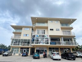 Um edifício com vários andares, com um andar térreo que inclui um café e um restaurante chamado "Champion's Sports Bar Café & Restaurant".